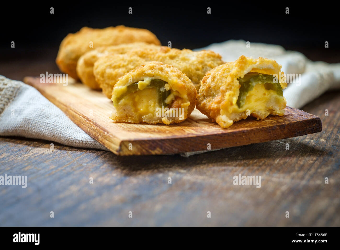 Crispy fried cheddar cheese jalapeno popper bites served on wooden ...