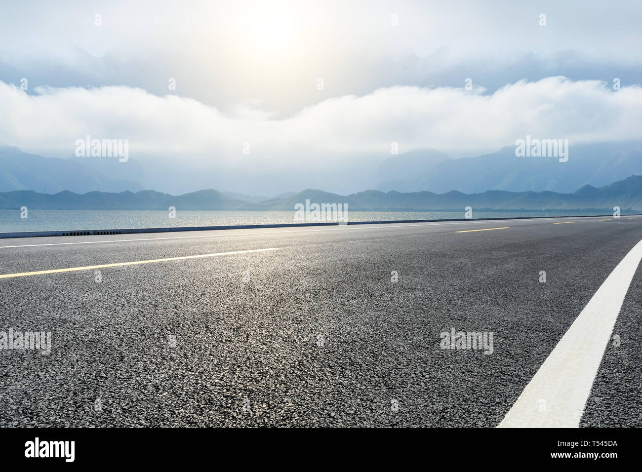 Empty asphalt road and river with mountain landscape Stock Photo - Alamy