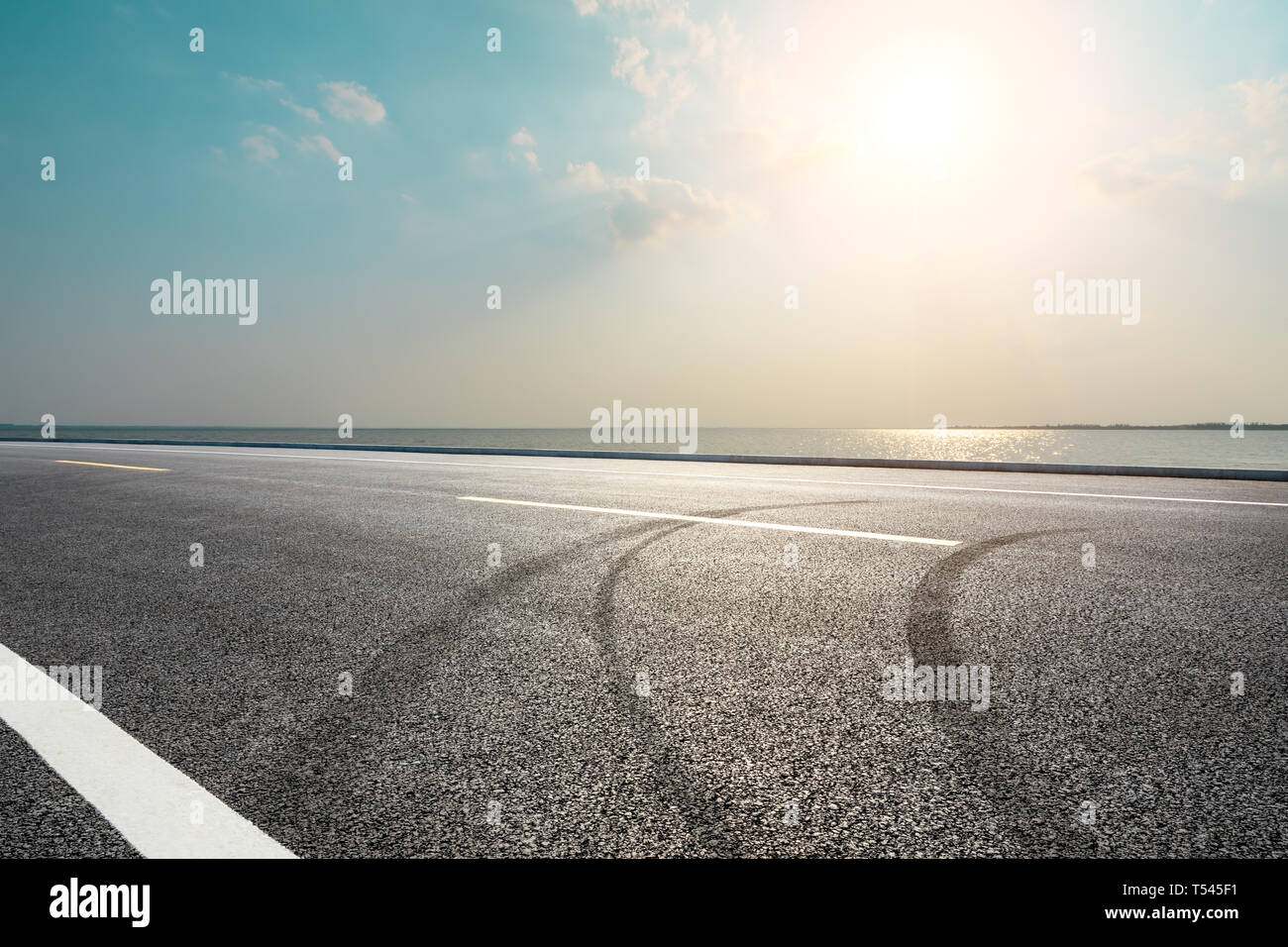 Empty asphalt road and blue sea with sky background Stock Photo - Alamy