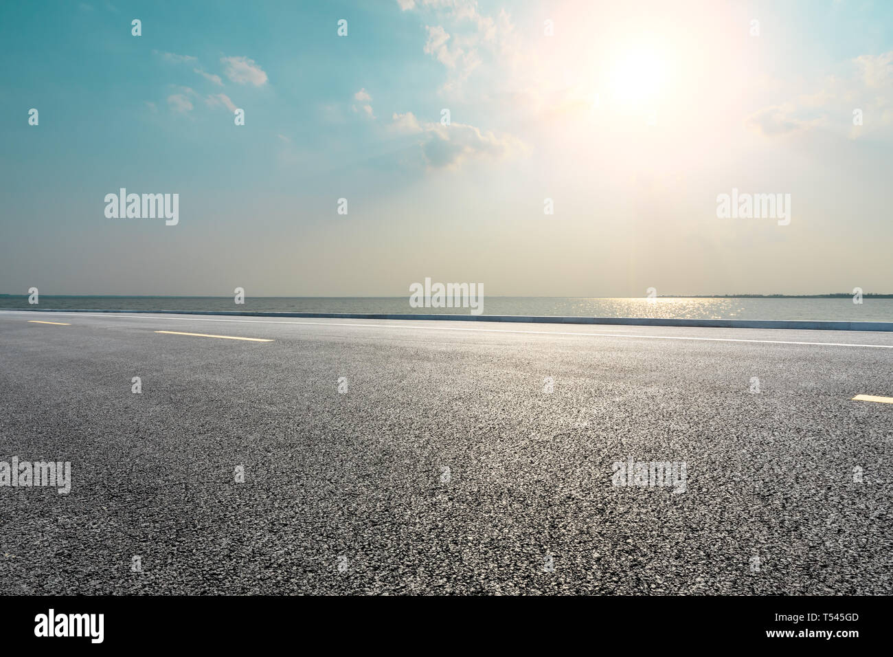 Empty asphalt road and blue sea with sky background Stock Photo - Alamy