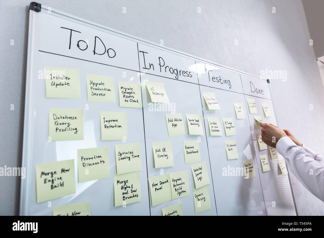 Side View Of Businessman Writing On Sticky Notes Attached To White ...