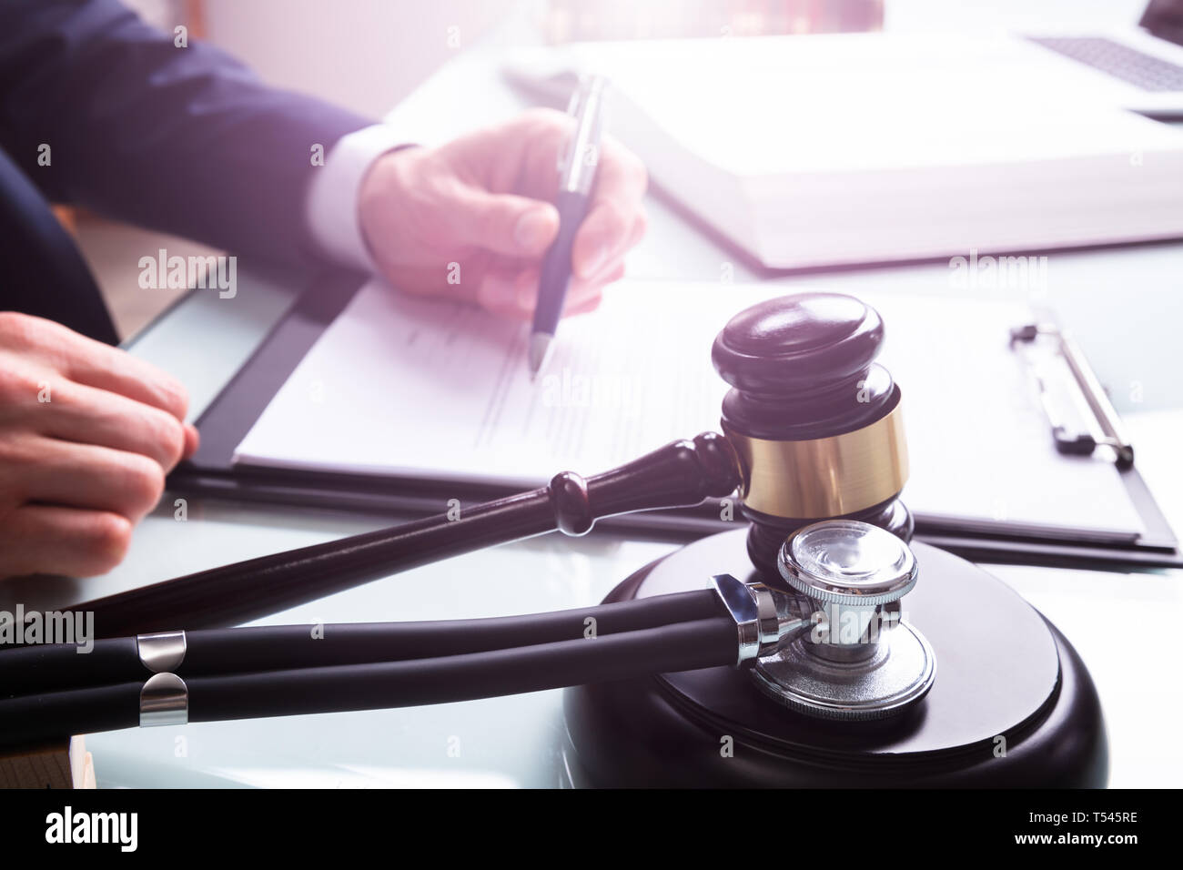 Judge Writing On Legal Documents With Mallet And Stethoscope Over Sound ...