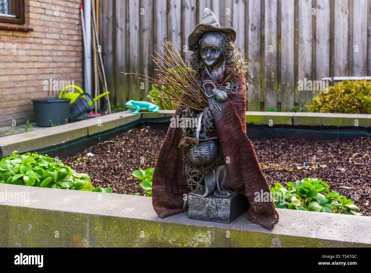 spooky witch statuette in a garden, outdoor halloween decorations ...