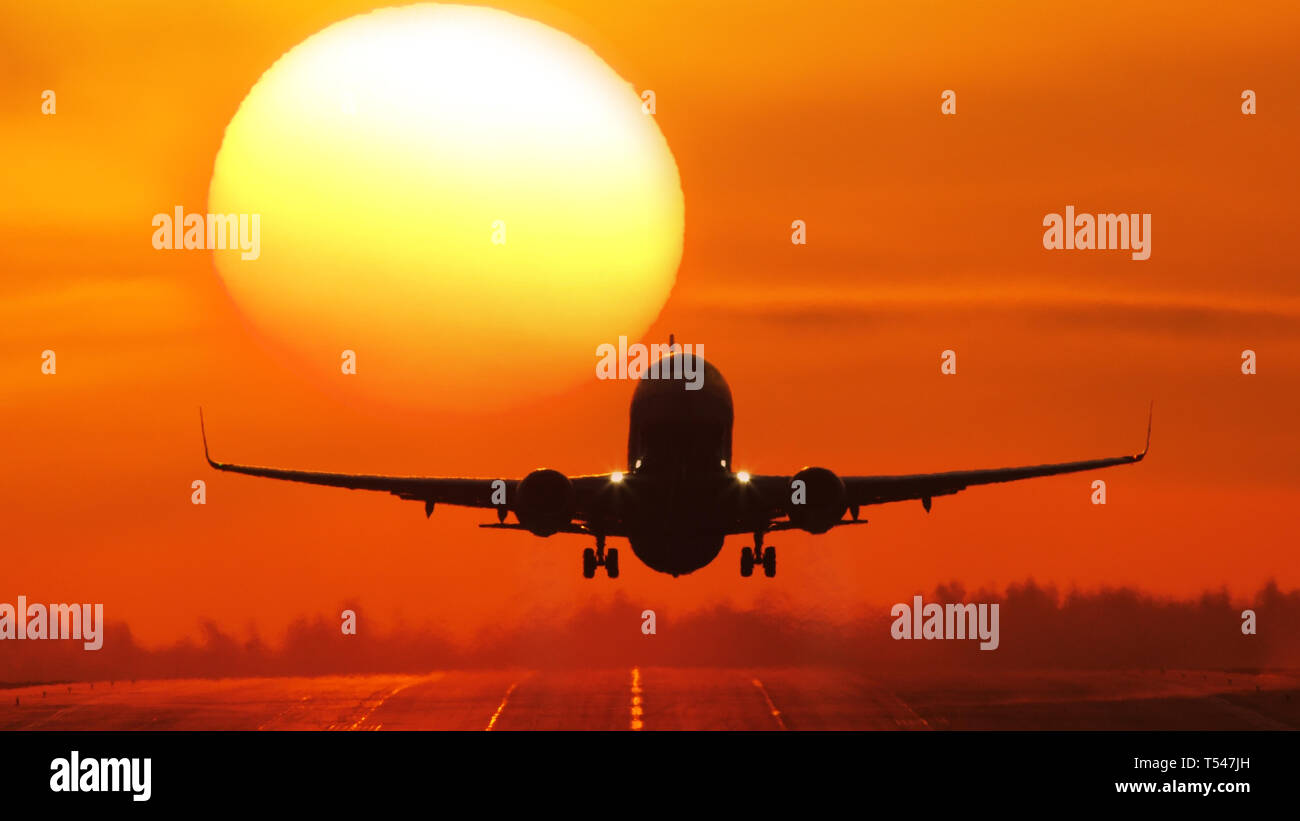 Airliner taking off at sunrise, passing the sun Stock Photo - Alamy