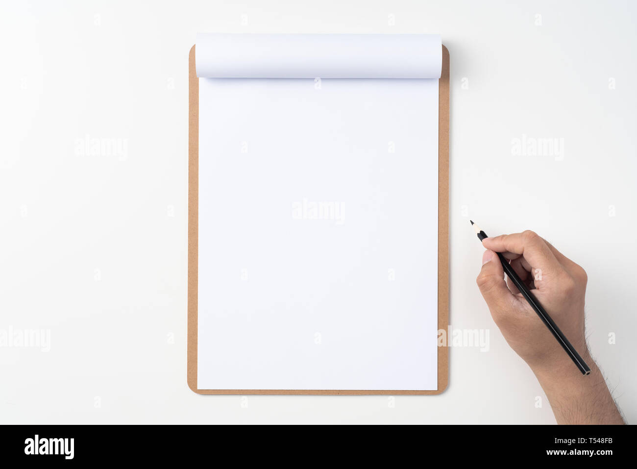 Design concept - top view of mans hand hold pencil on white A4 flipped ...