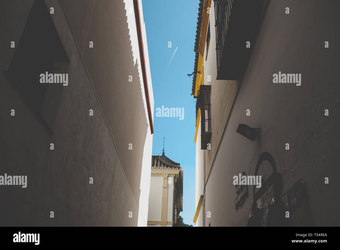 Narrow passageway with tall buildings in Seville, Spain – March 2019 ...