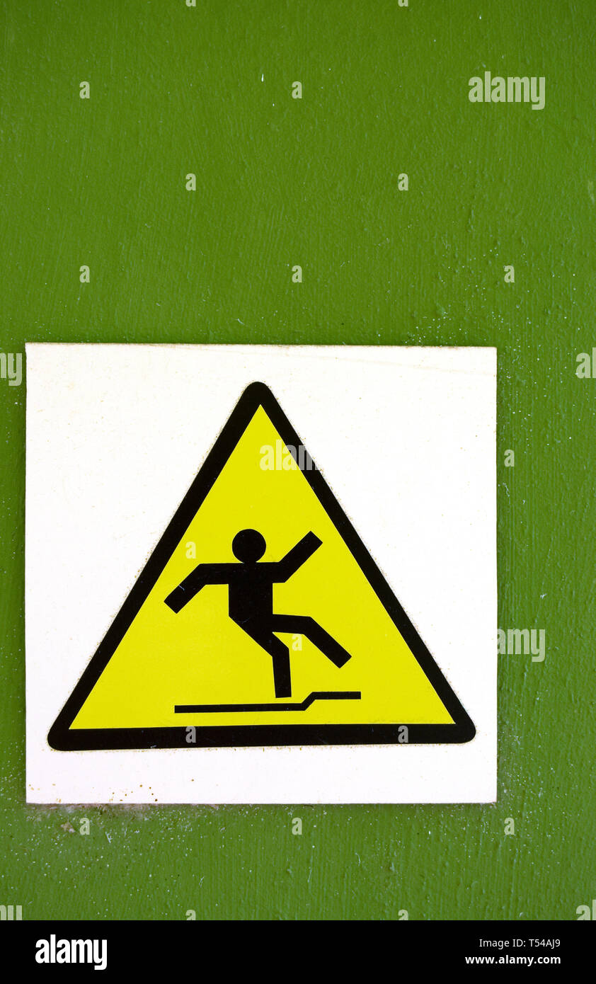 Slippery Yellow Sign on Green Wall Stock Photo - Alamy