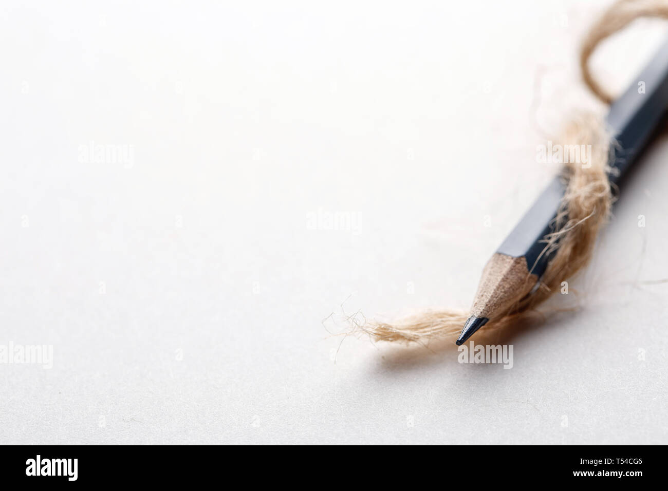 Gray pencil with a rope on the right side of a white background ...