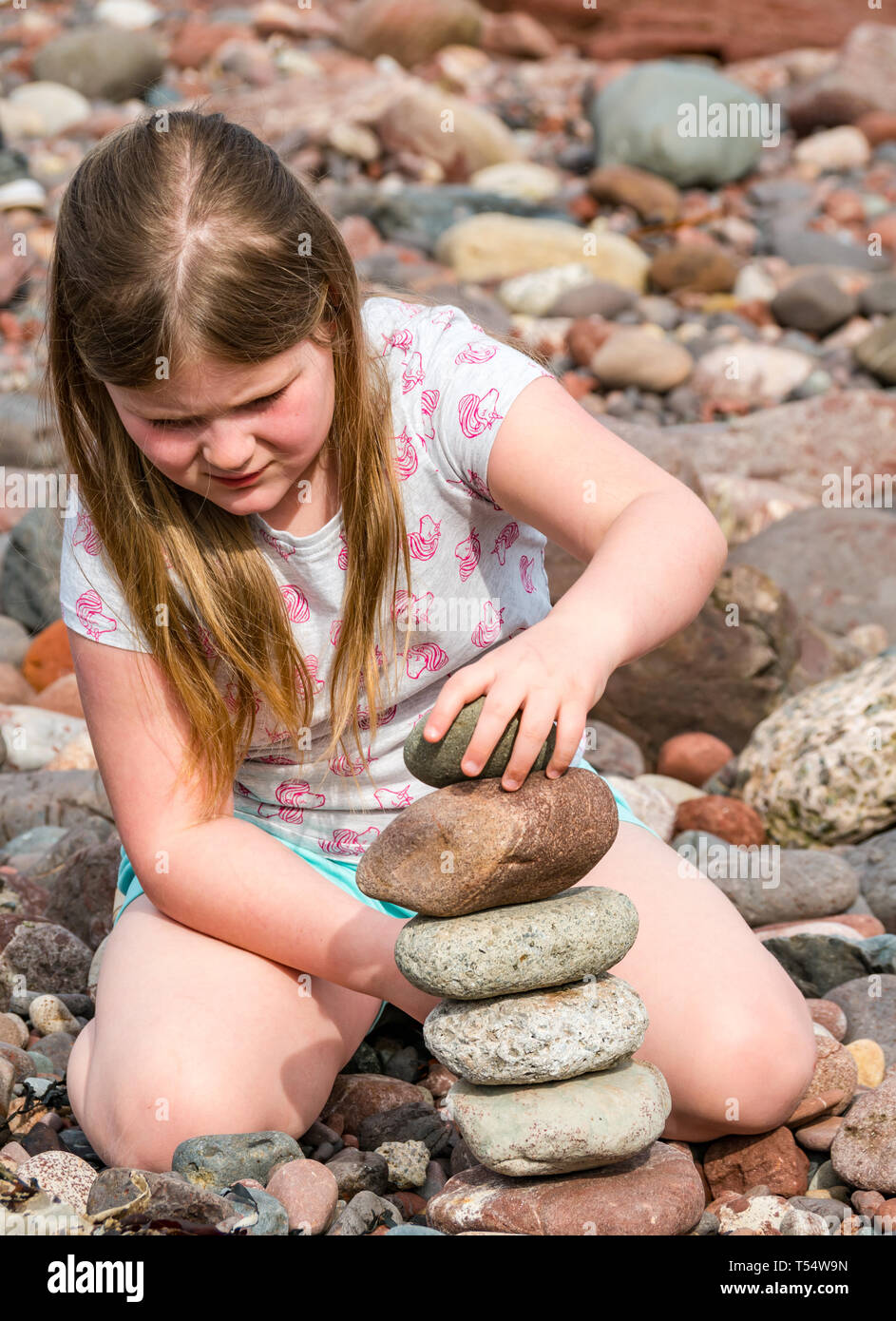Child stacking stones hi-res stock photography and images - Alamy