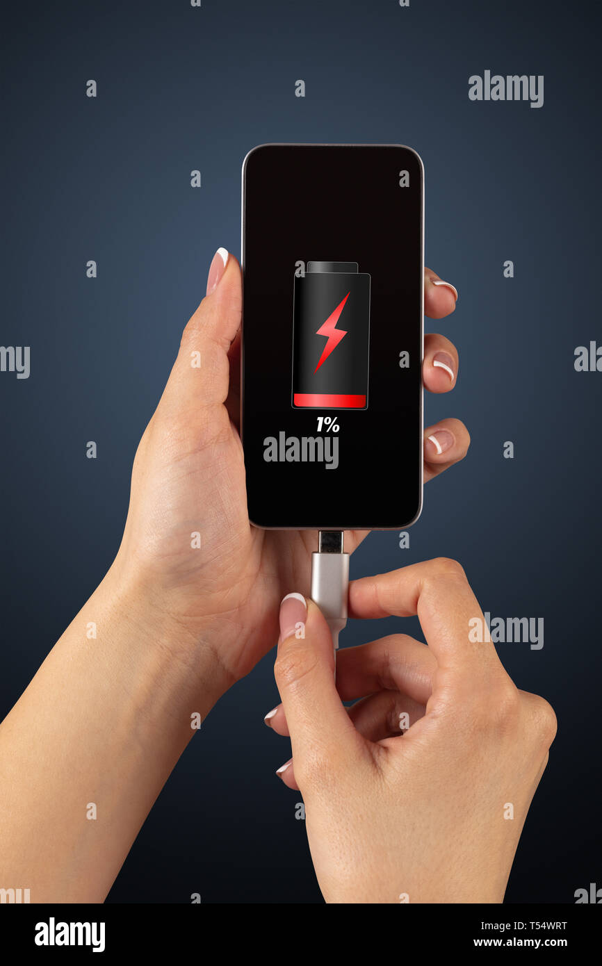 Elegant hand charging cellphone with low battery Stock Photo - Alamy