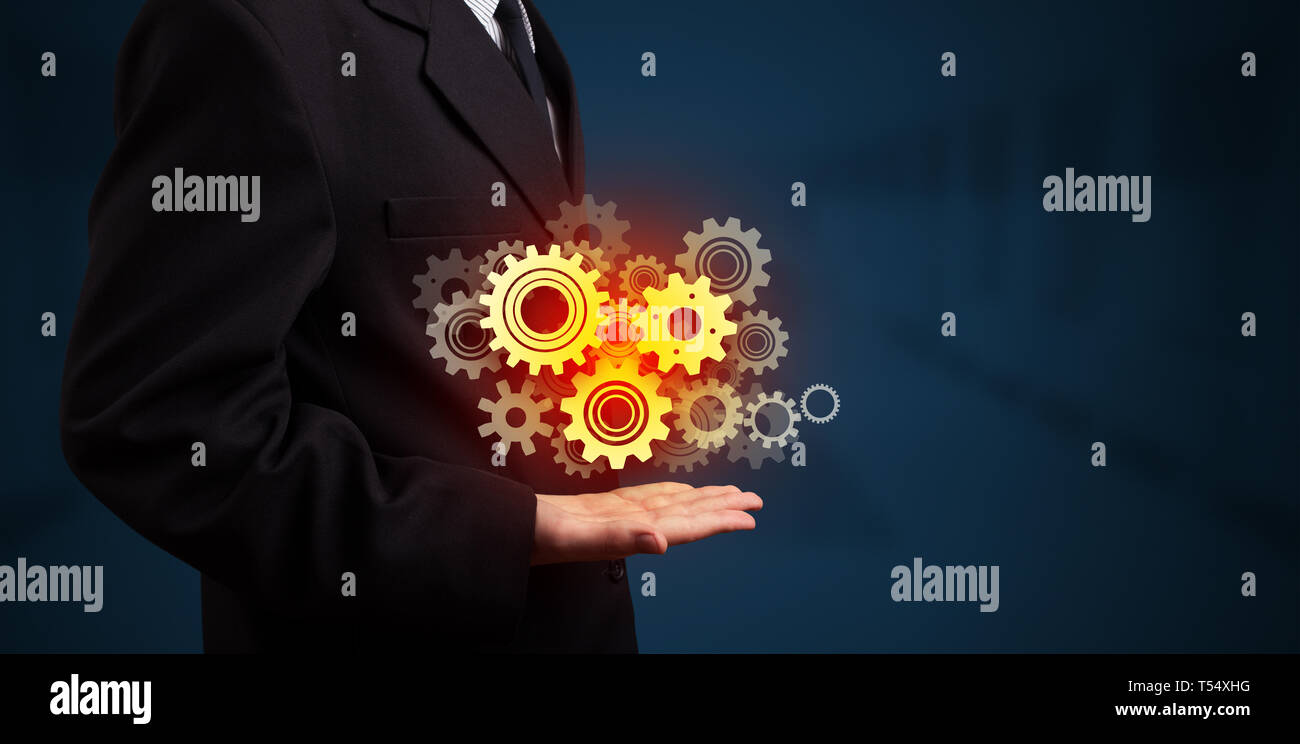 Hand holding gears in his hand Stock Photo - Alamy