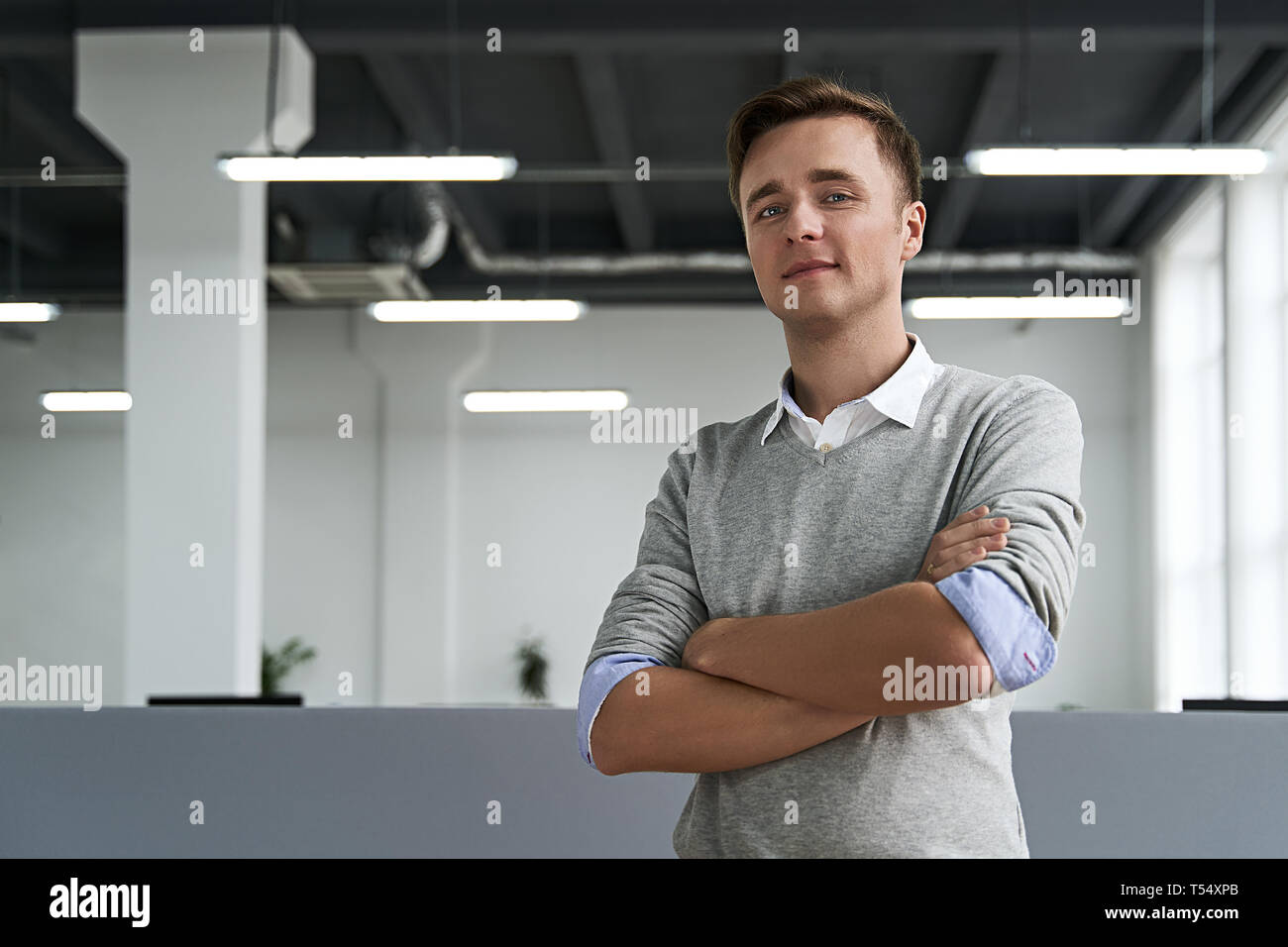 Portrait of a handsome young software developer with arms crossed ...