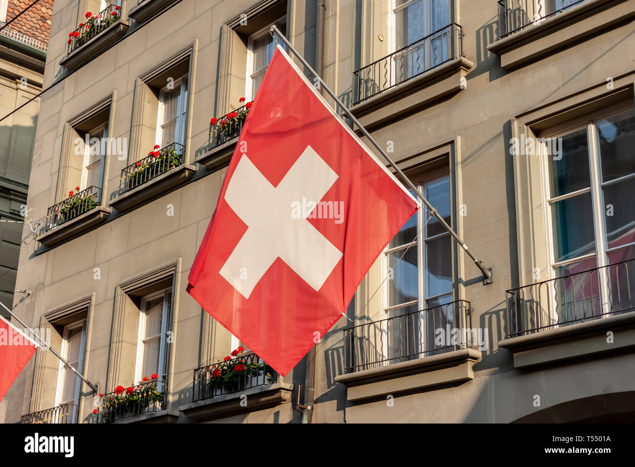 Switzerland flag hanging on building in Bern city Stock Photo - Alamy
