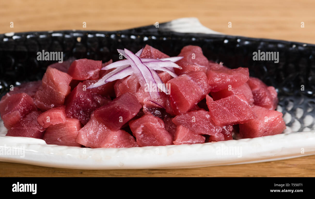 bluefin tuna tartare with chopped red onion, served on a fish-shaped ...