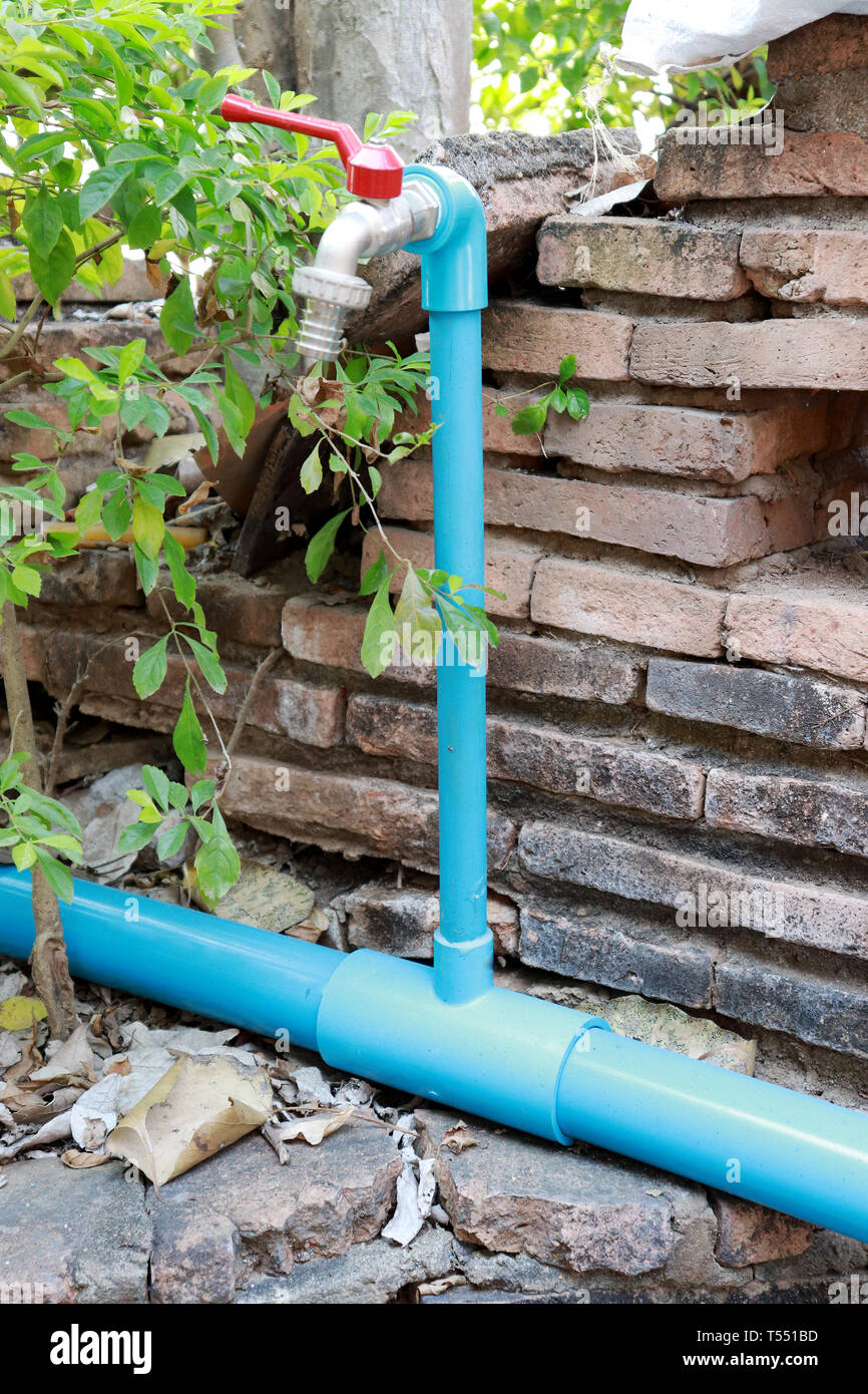 Water tap. Blue tube faucet and the red shutter valve Stock Photo - Alamy