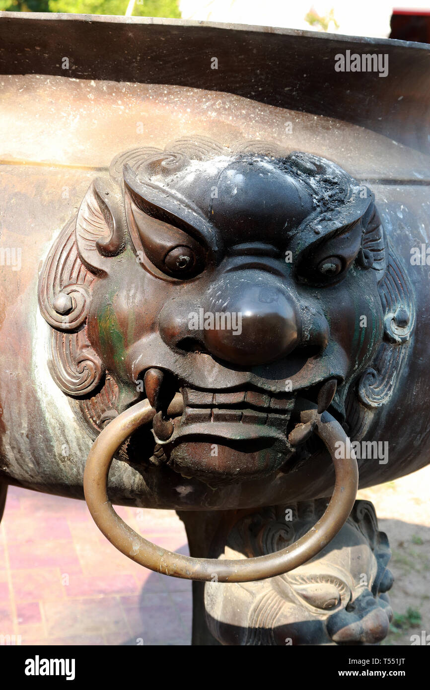 Singha statue on old joss stick pot ncense burner Stock Photo - Alamy