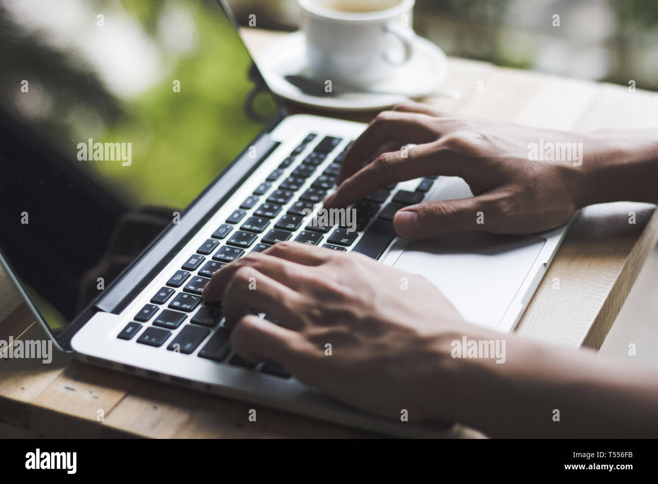 hand typing keyboard on wooden table at coffee shop Stock Photo - Alamy