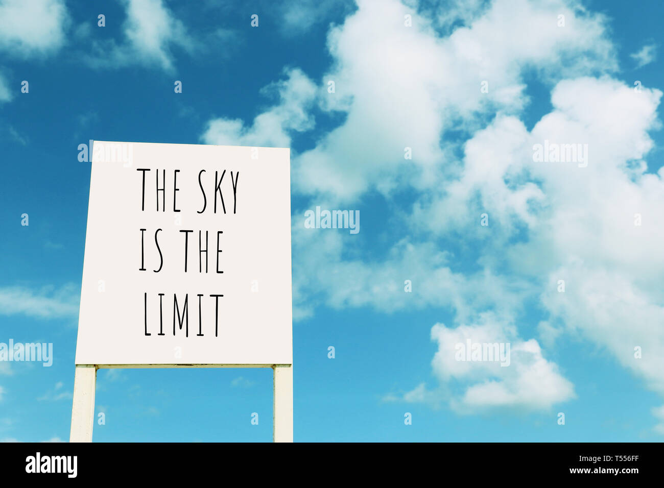 sign against blue sky with clouds with the text - the sky is the limit ...