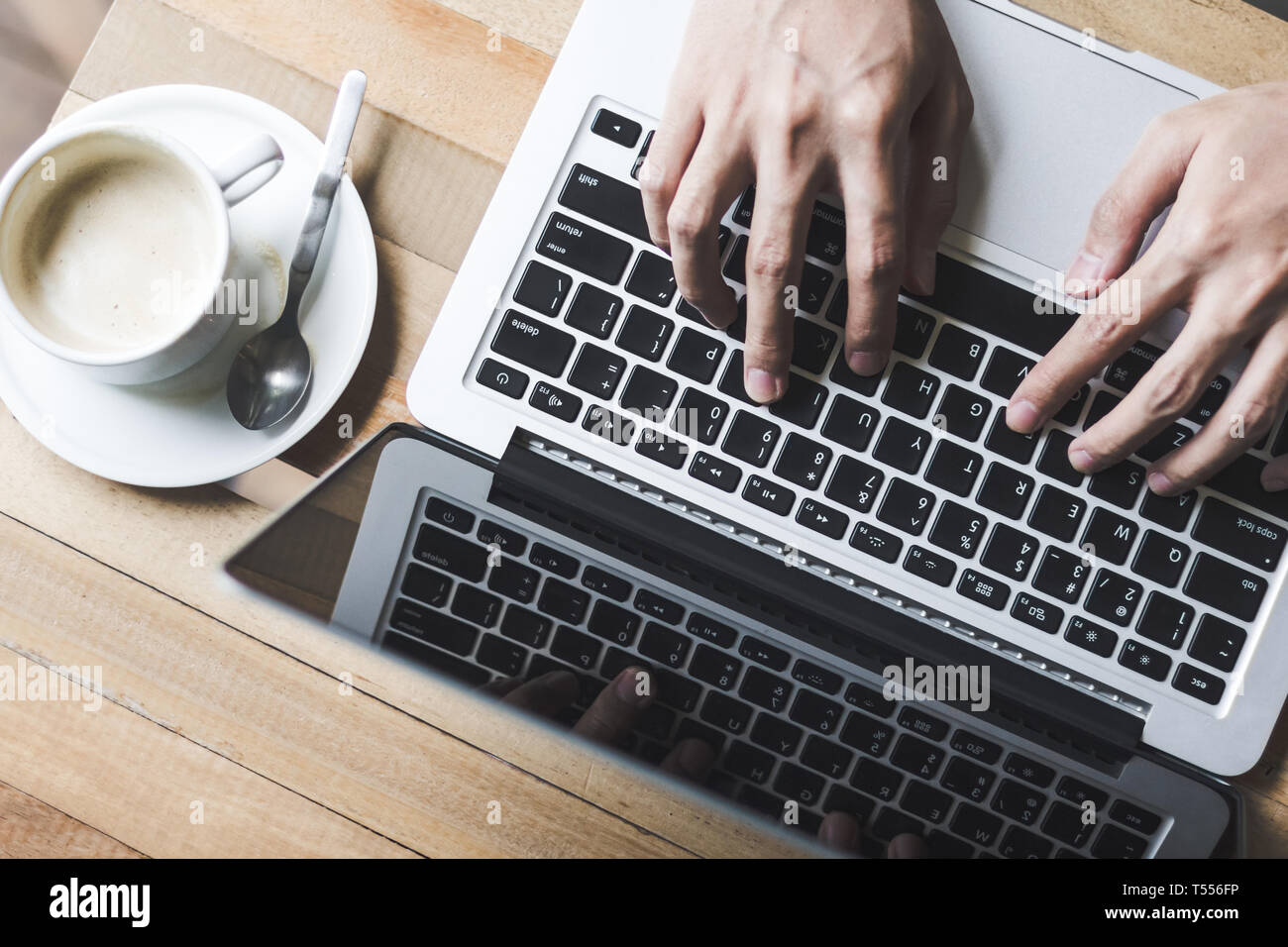 hand typing keyboard on wooden table at coffee shop Stock Photo - Alamy