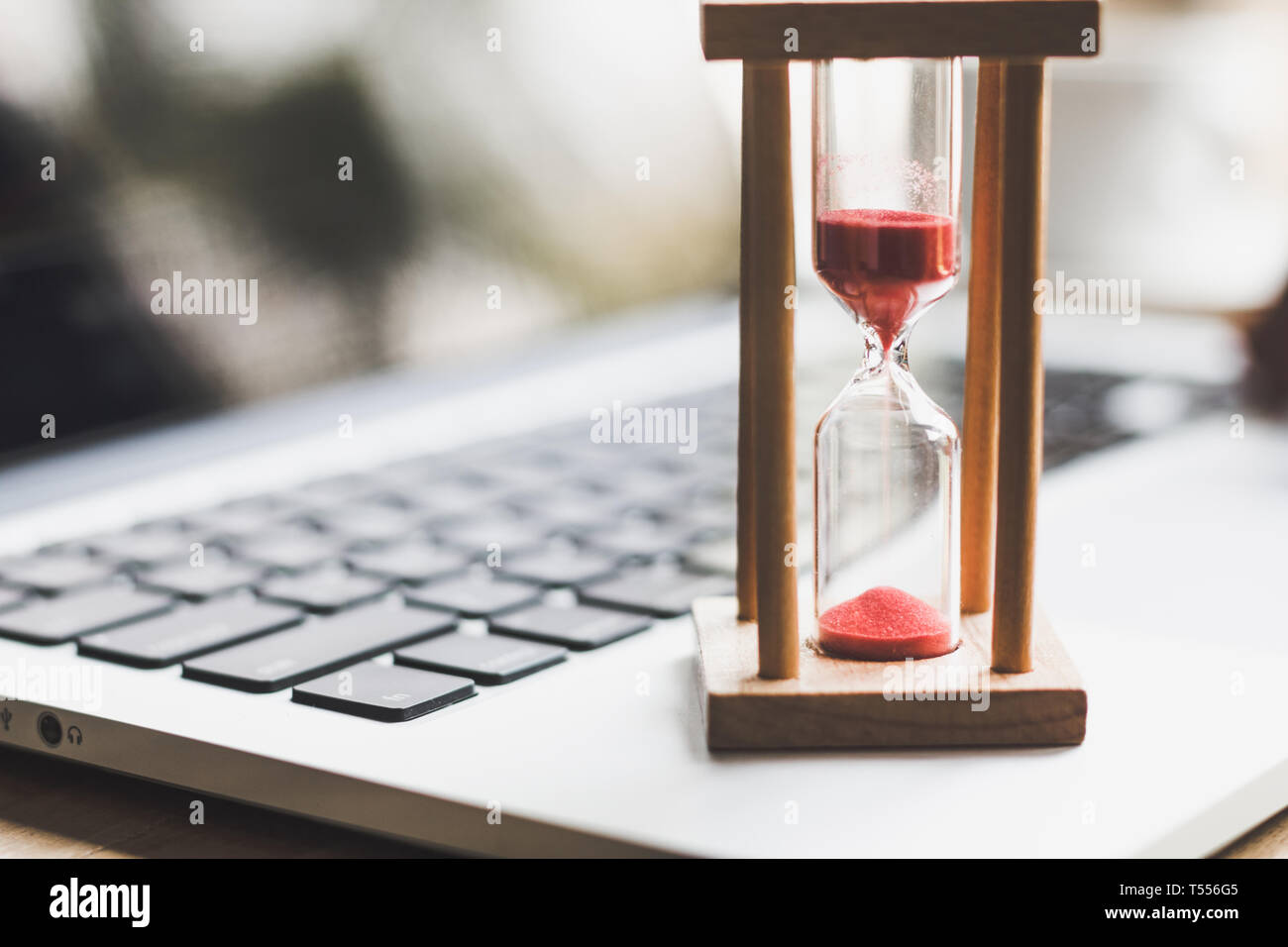 sand clock timer on laptop .symbol of time Stock Photo - Alamy