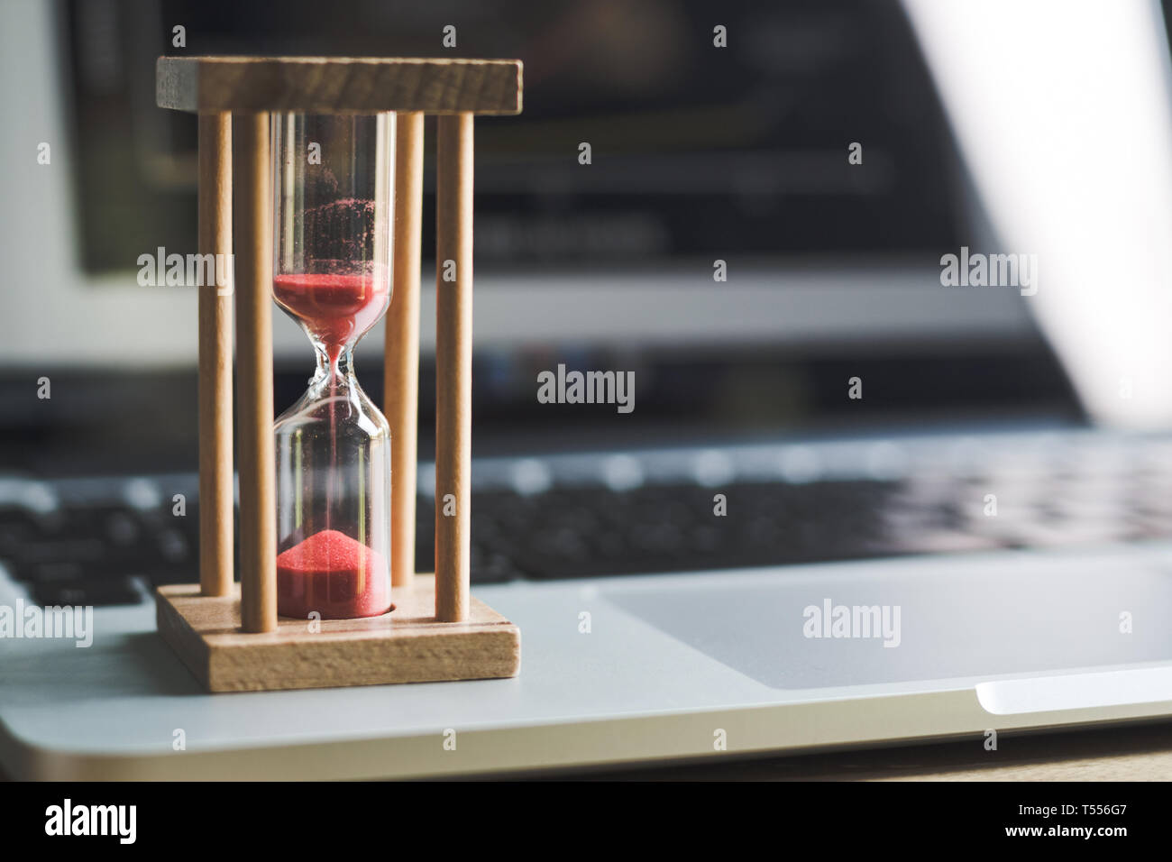 sand clock timer on laptop .symbol of time Stock Photo - Alamy