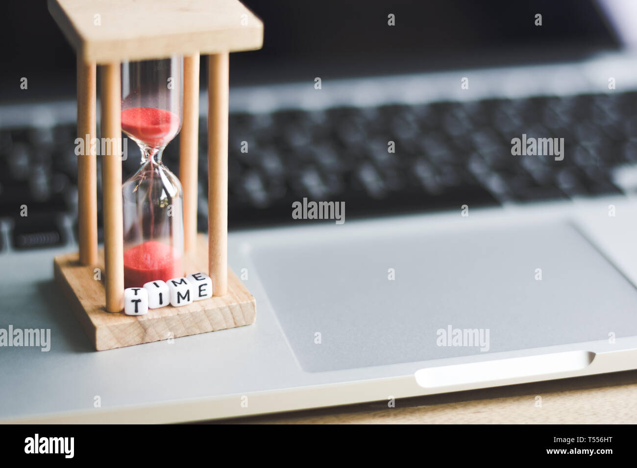 sand clock timer on laptop with "TIME" alphabet cube letter .symbol of ...
