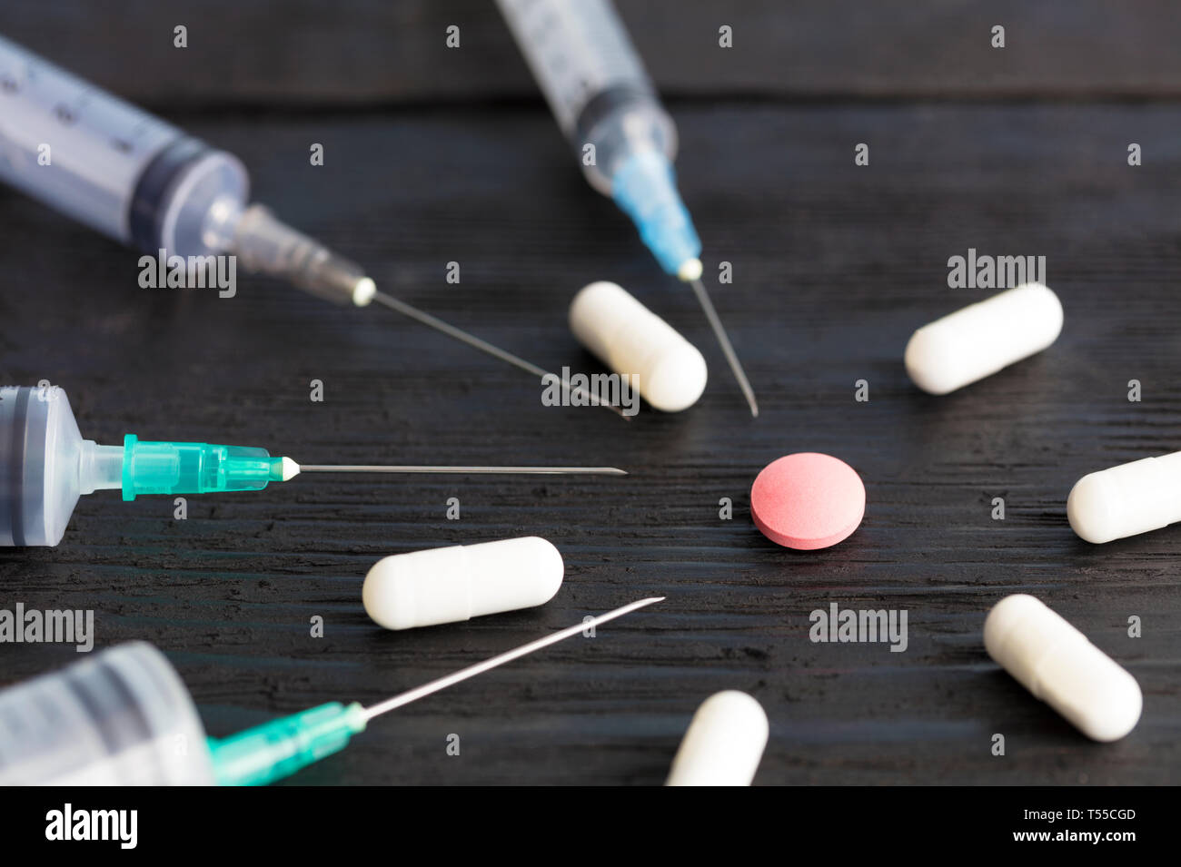 Medical syringes of various capacities, capsules, tablets lie on an old ...