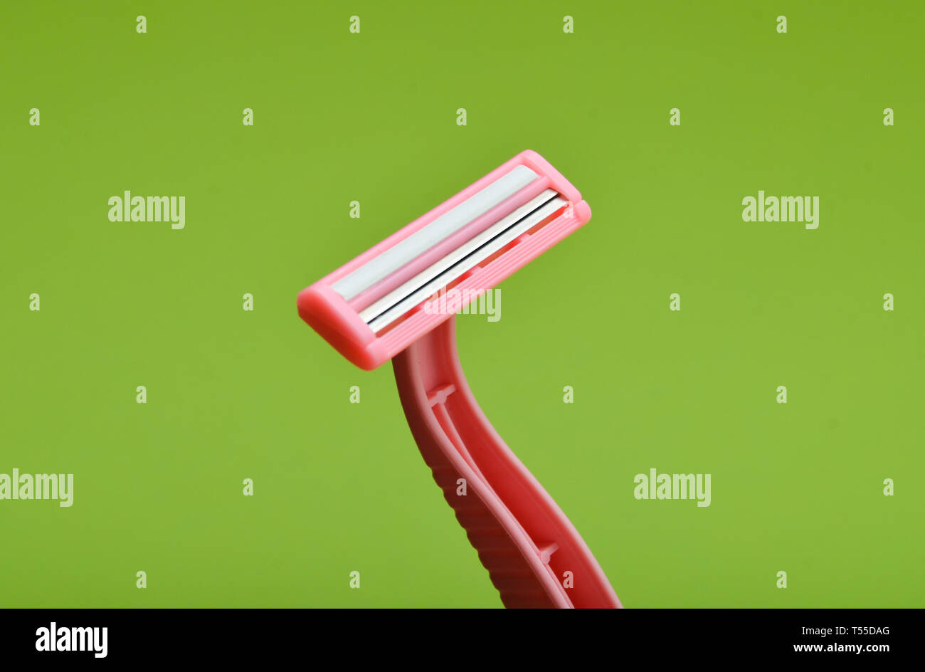 Pink disposable razor for depilation on a green background Stock Photo ...
