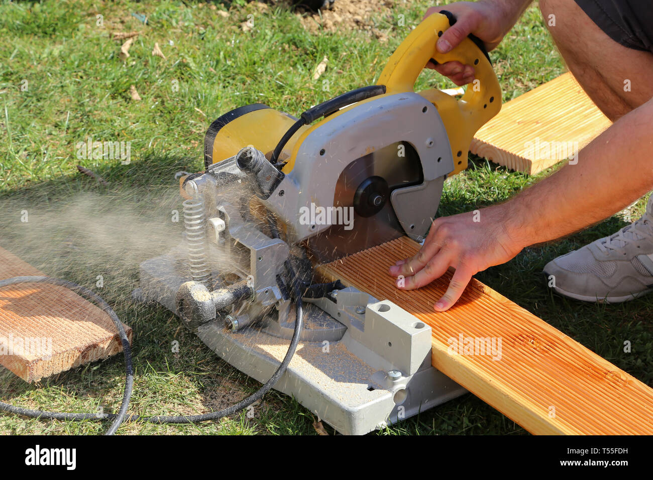 A worker saw wood with a chop saw Stock Photo - Alamy