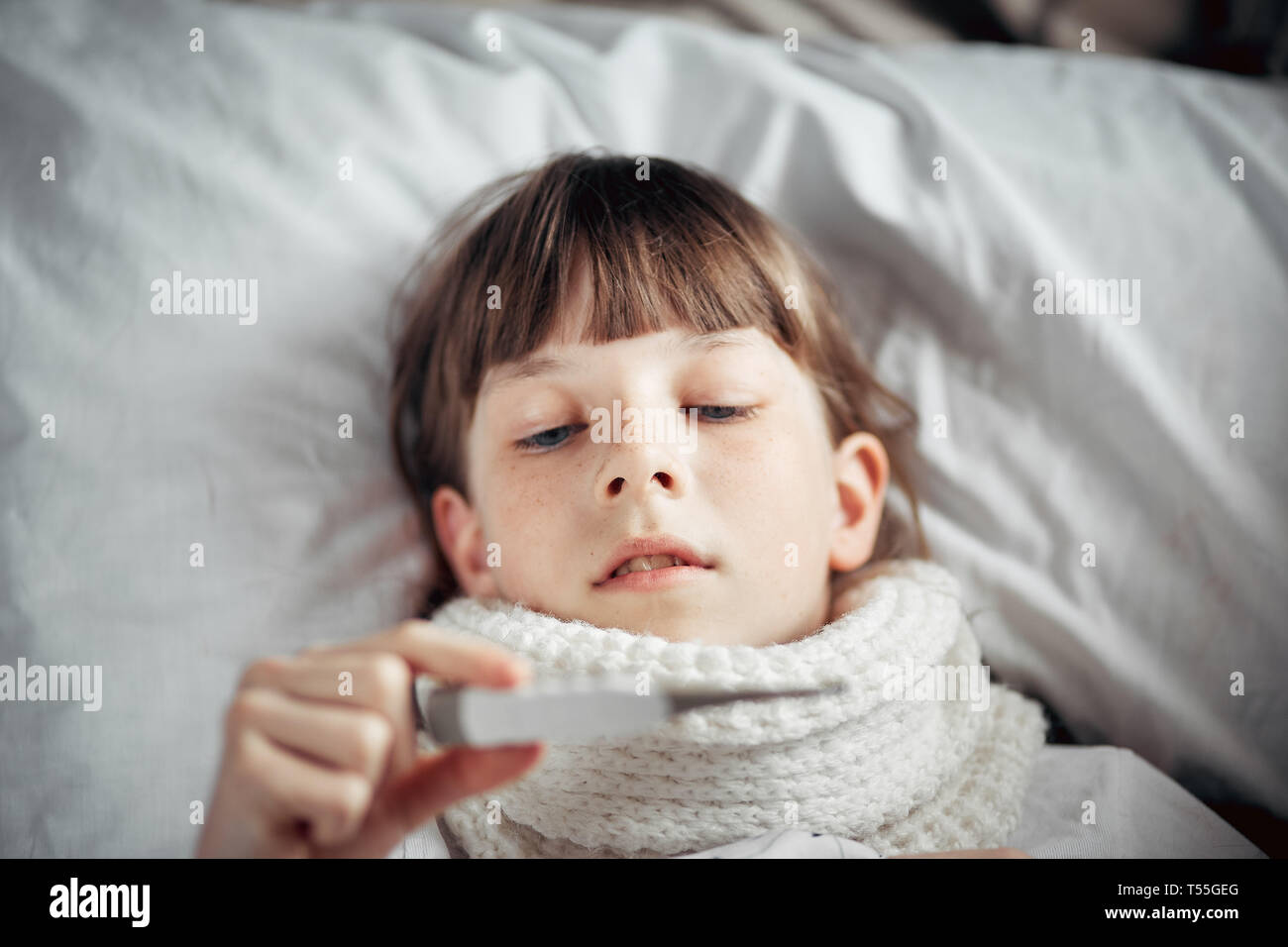 teenage girl with a cold measures the temperature Stock Photo - Alamy