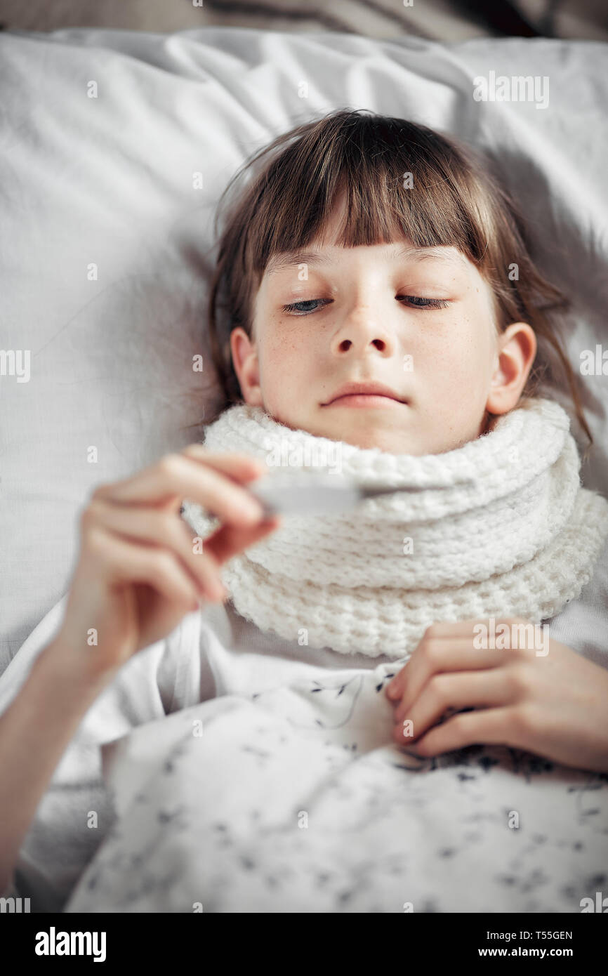 teenage girl with a cold measures the temperature Stock Photo - Alamy