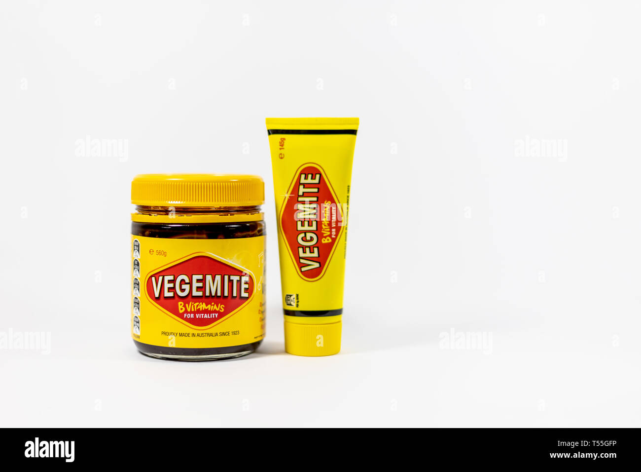 A jar and a tube of Vegemite side by side, set against a white ...