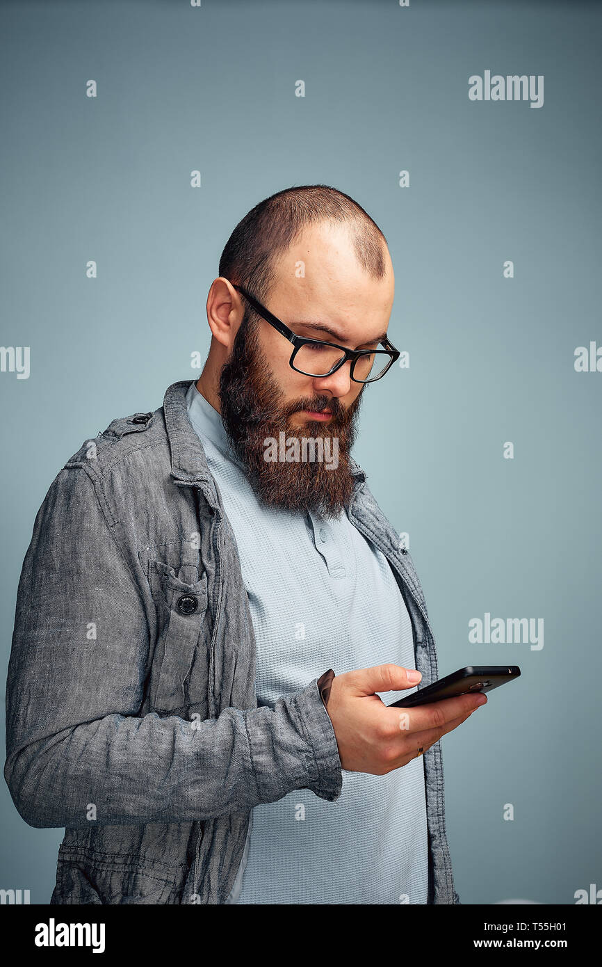 lifestyle brooding man with a beard and a telephone, background ...