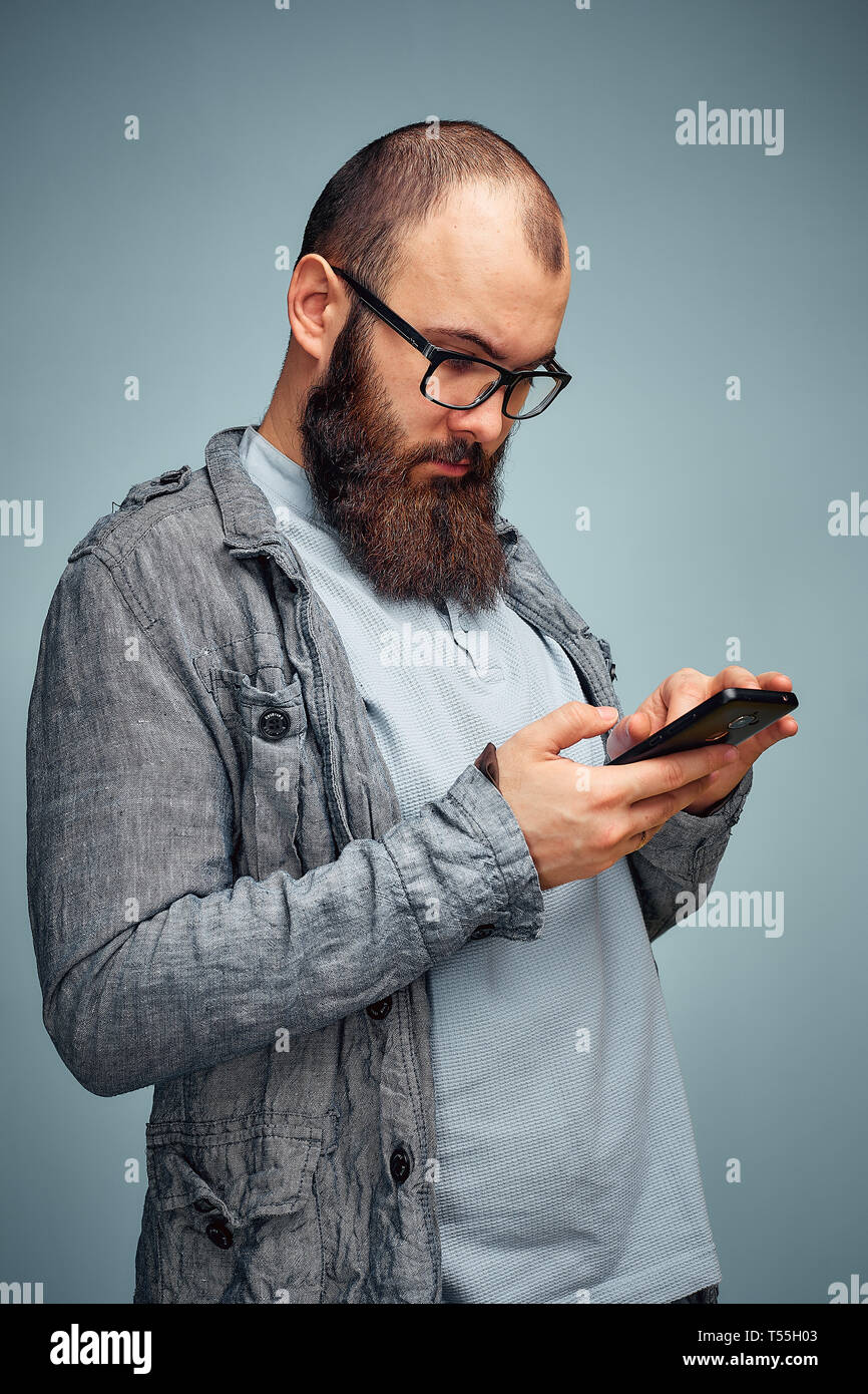 lifestyle brooding man with a beard and a telephone, background ...
