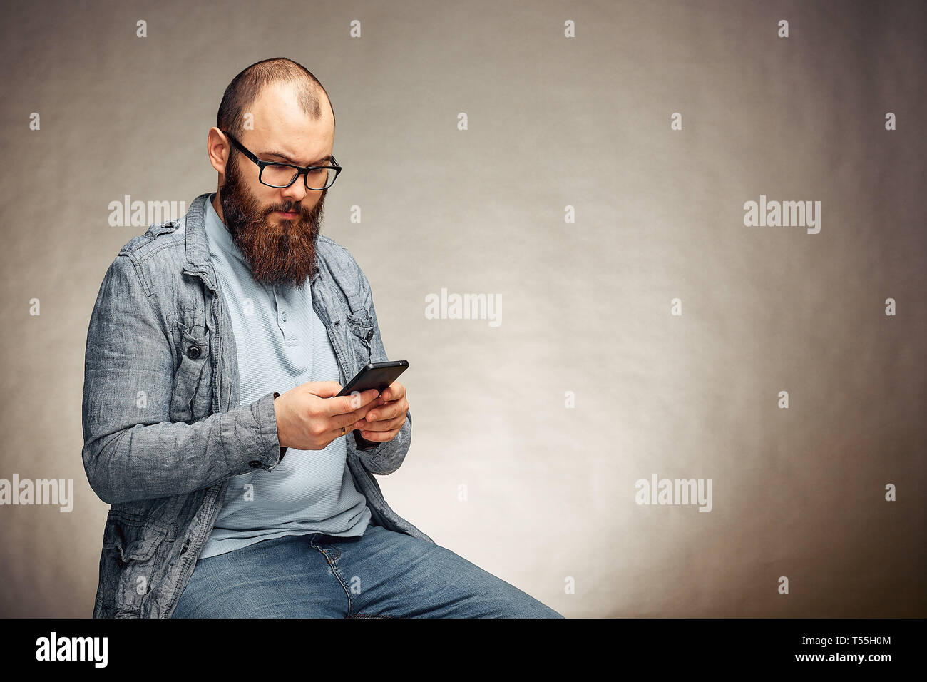 lifestyle brooding man with a beard and a telephone, background ...