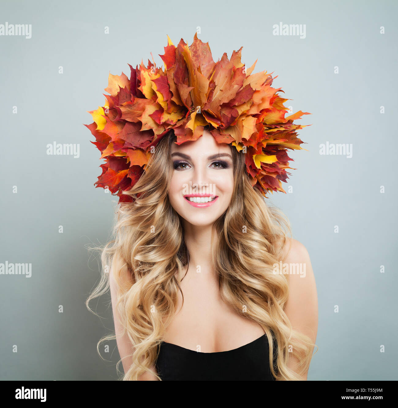 Cute autumn woman. Beautiful female model in colorful fall leaves ...