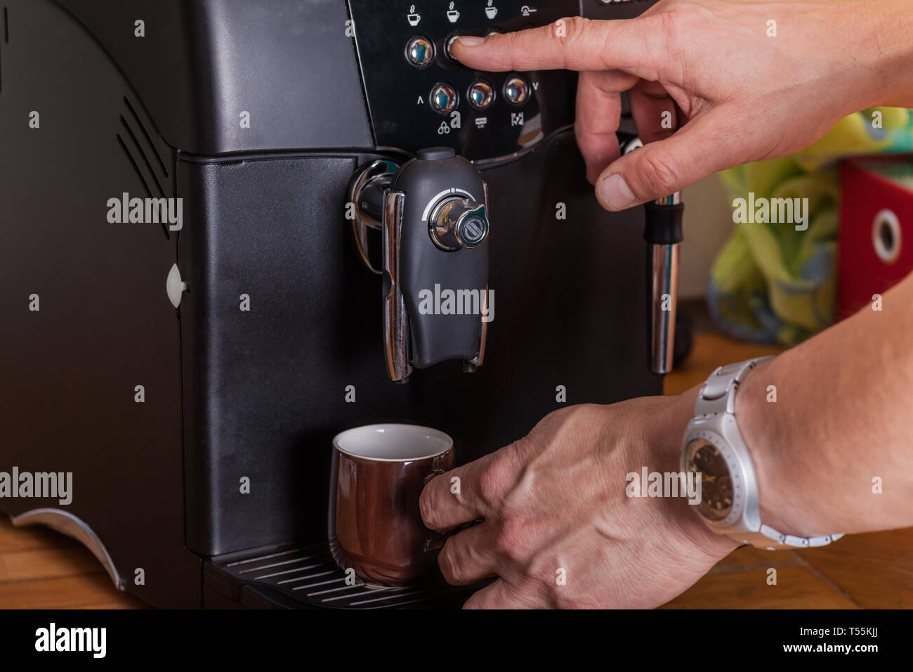 Two hands operate a coffee machine Stock Photo - Alamy