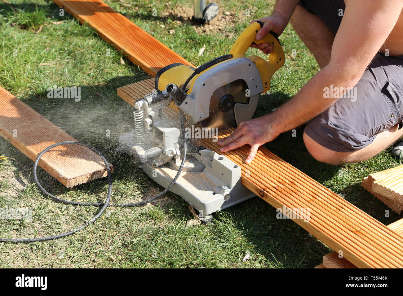 A worker saw wood with a chop saw Stock Photo - Alamy