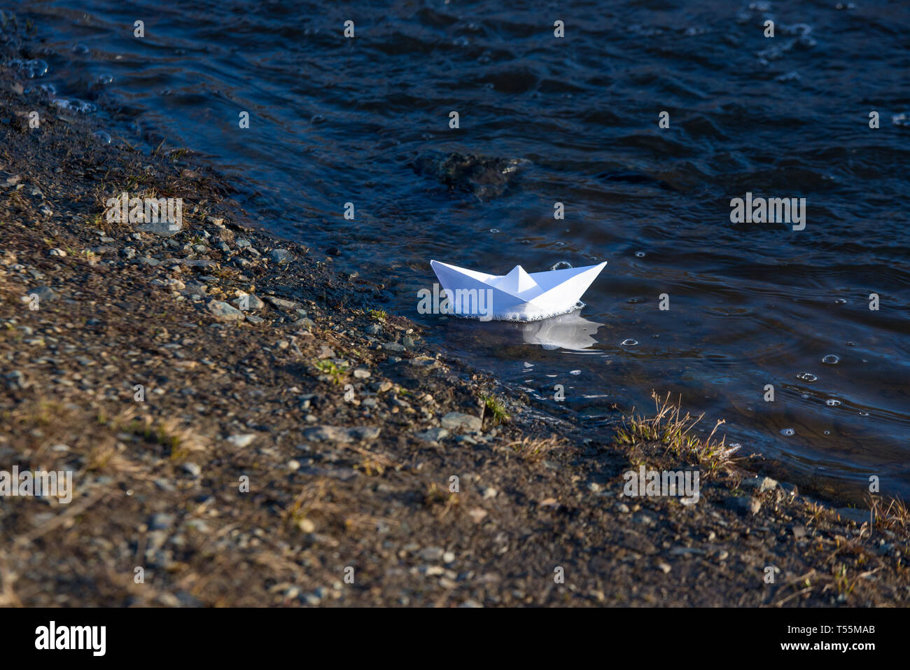 White paper toy boat on blue water near the shore Stock Photo - Alamy