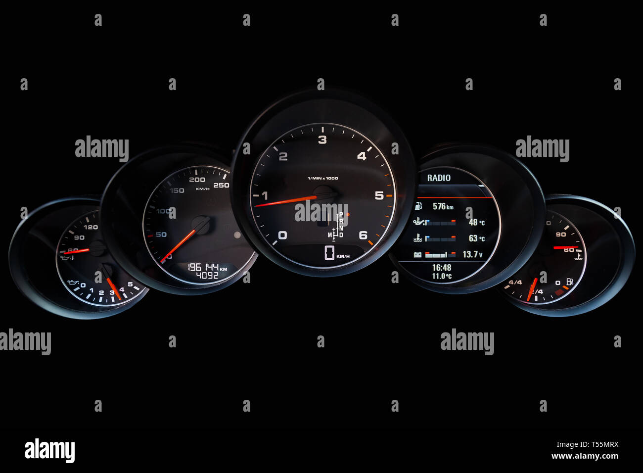 The dashboard of the car is glowing white and red with a speedometer ...