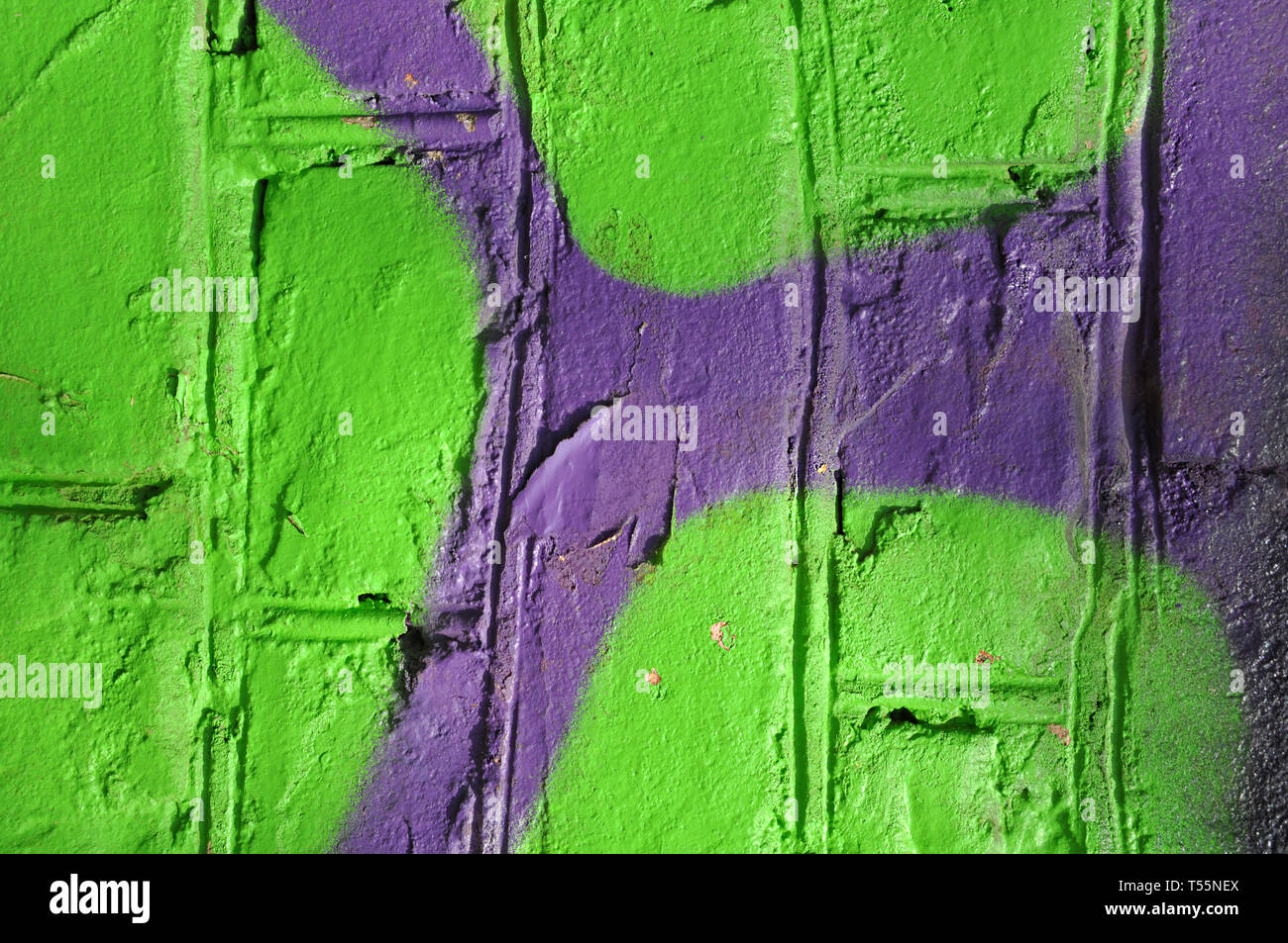 Lime-green and violet paints on the old brick wall, contrast background ...