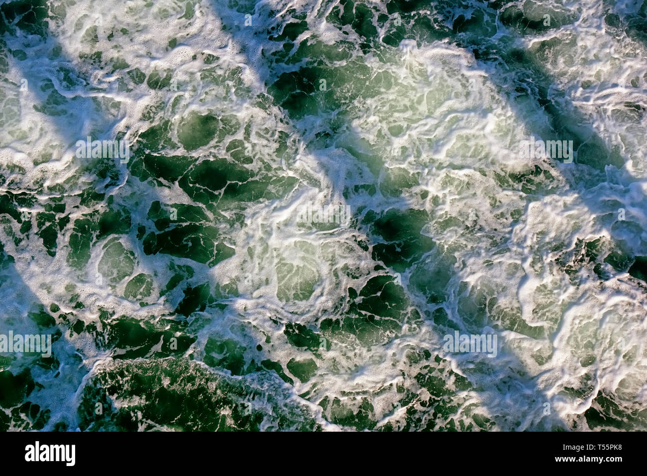 The churning ocean waters beneath a pier Stock Photo - Alamy