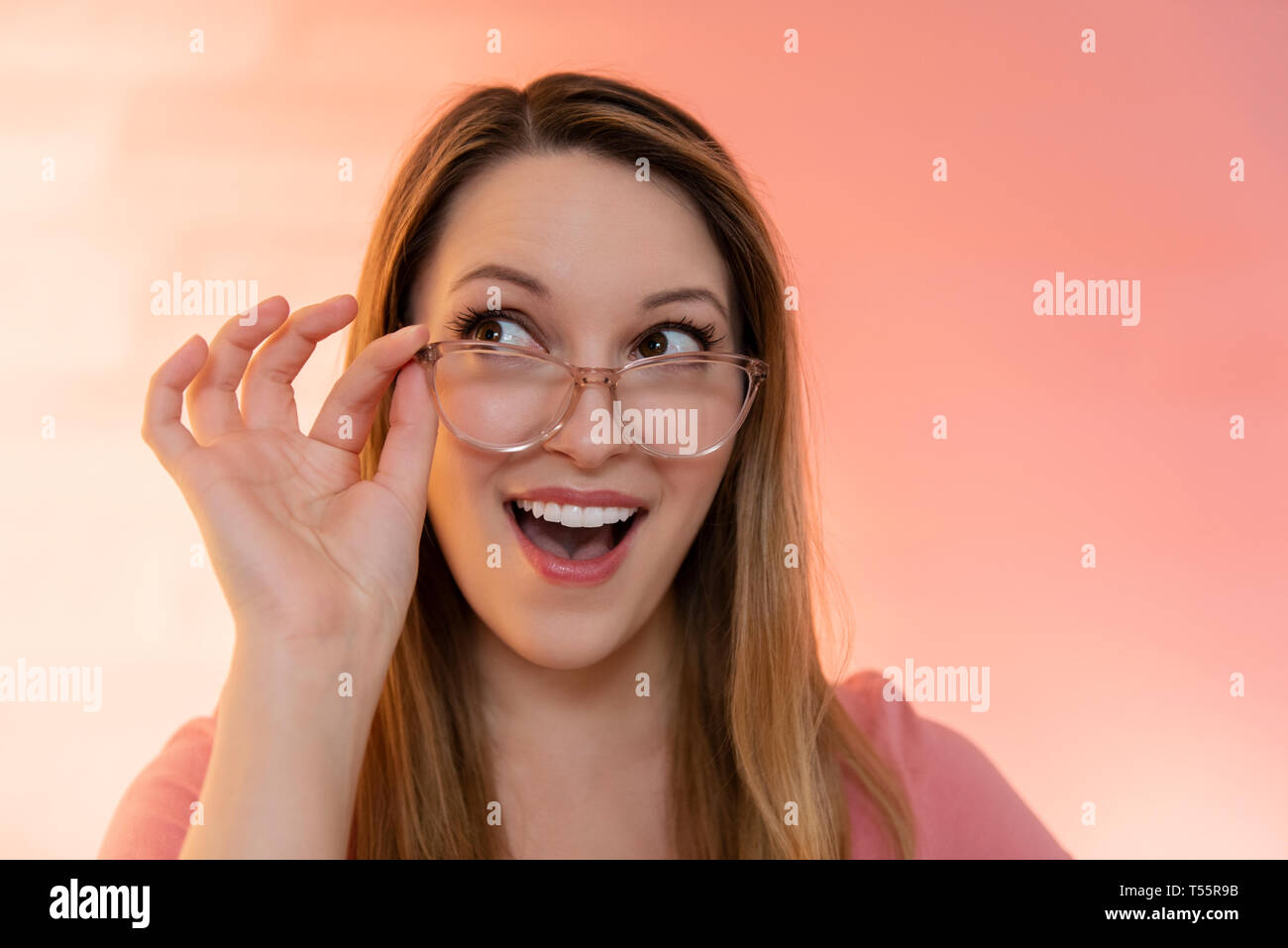 Excited young woman wearing glasses Stock Photo - Alamy