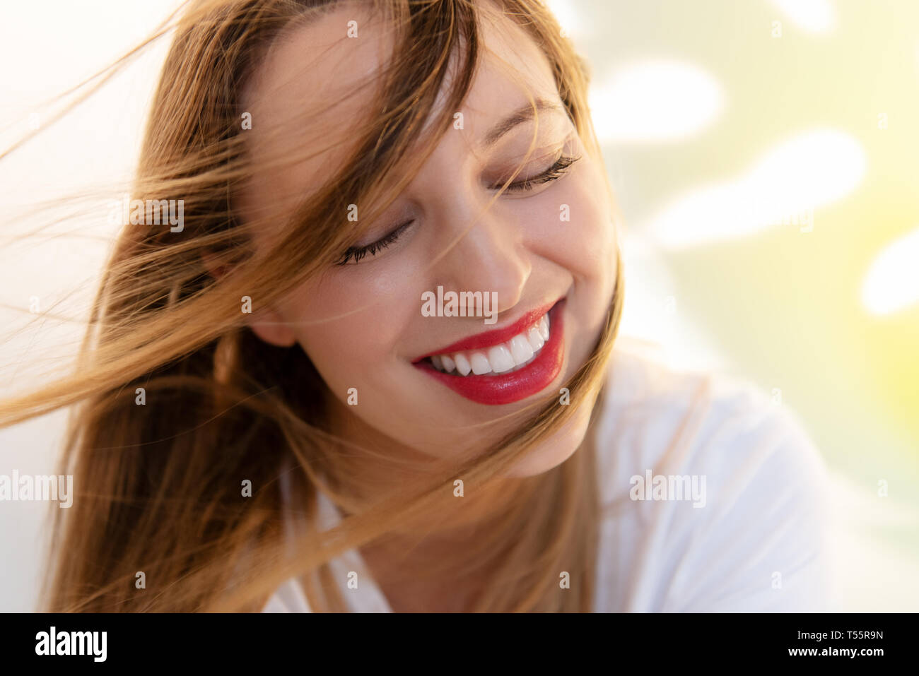 Portrait of windswept young woman wearing red lipstick Stock Photo - Alamy