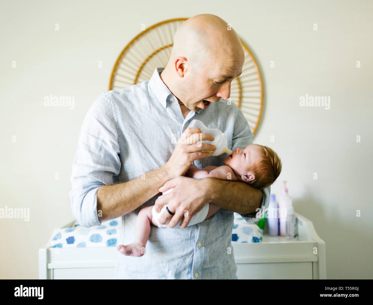 Man feeding his baby son Stock Photo - Alamy