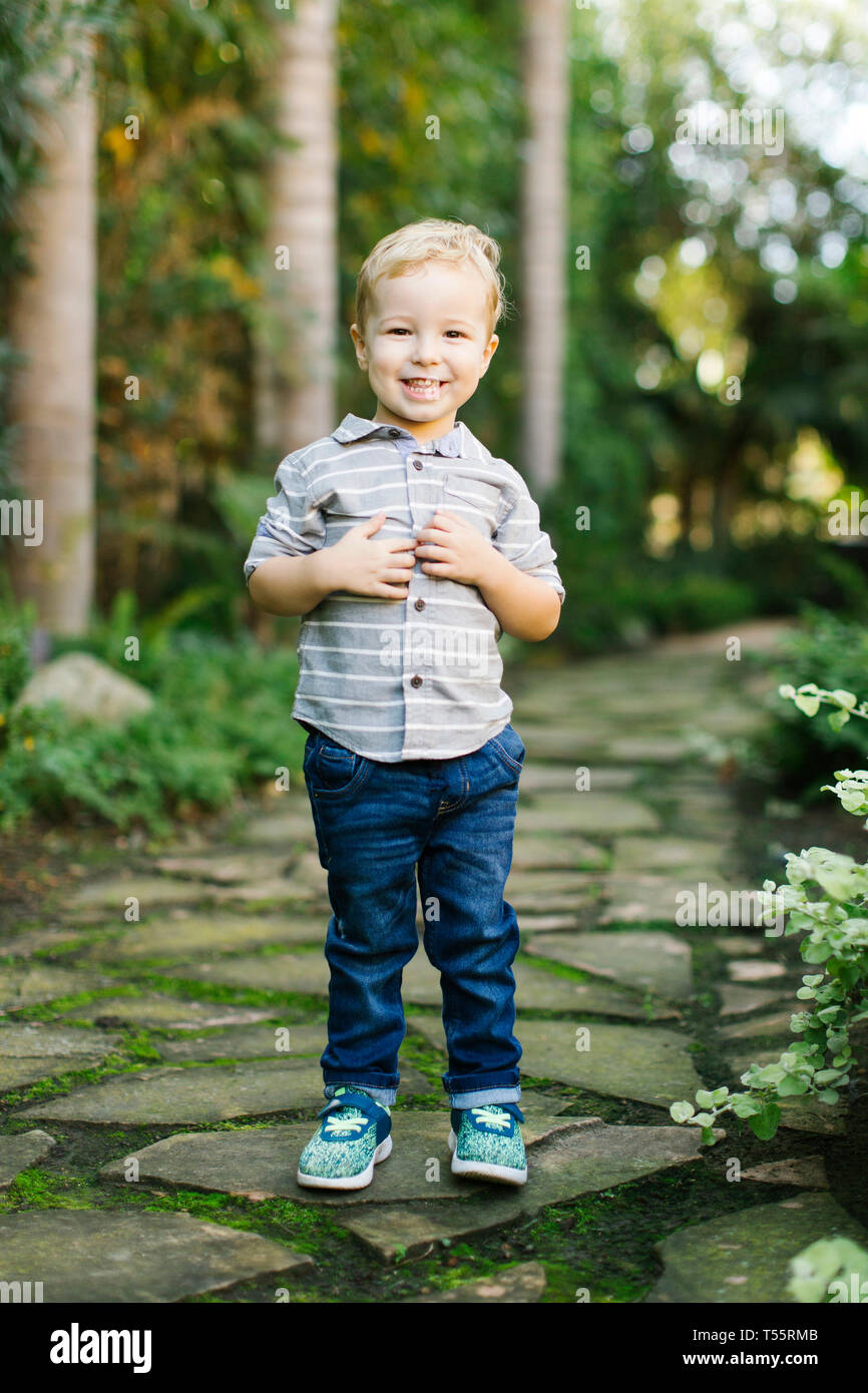 Smiling boy standing in garden Stock Photo - Alamy