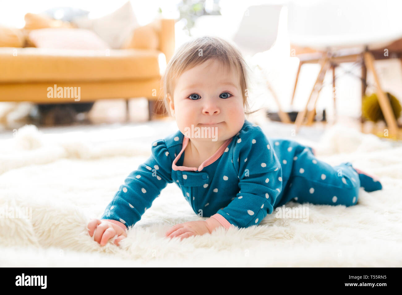 Baby girl lying on rug Stock Photo - Alamy