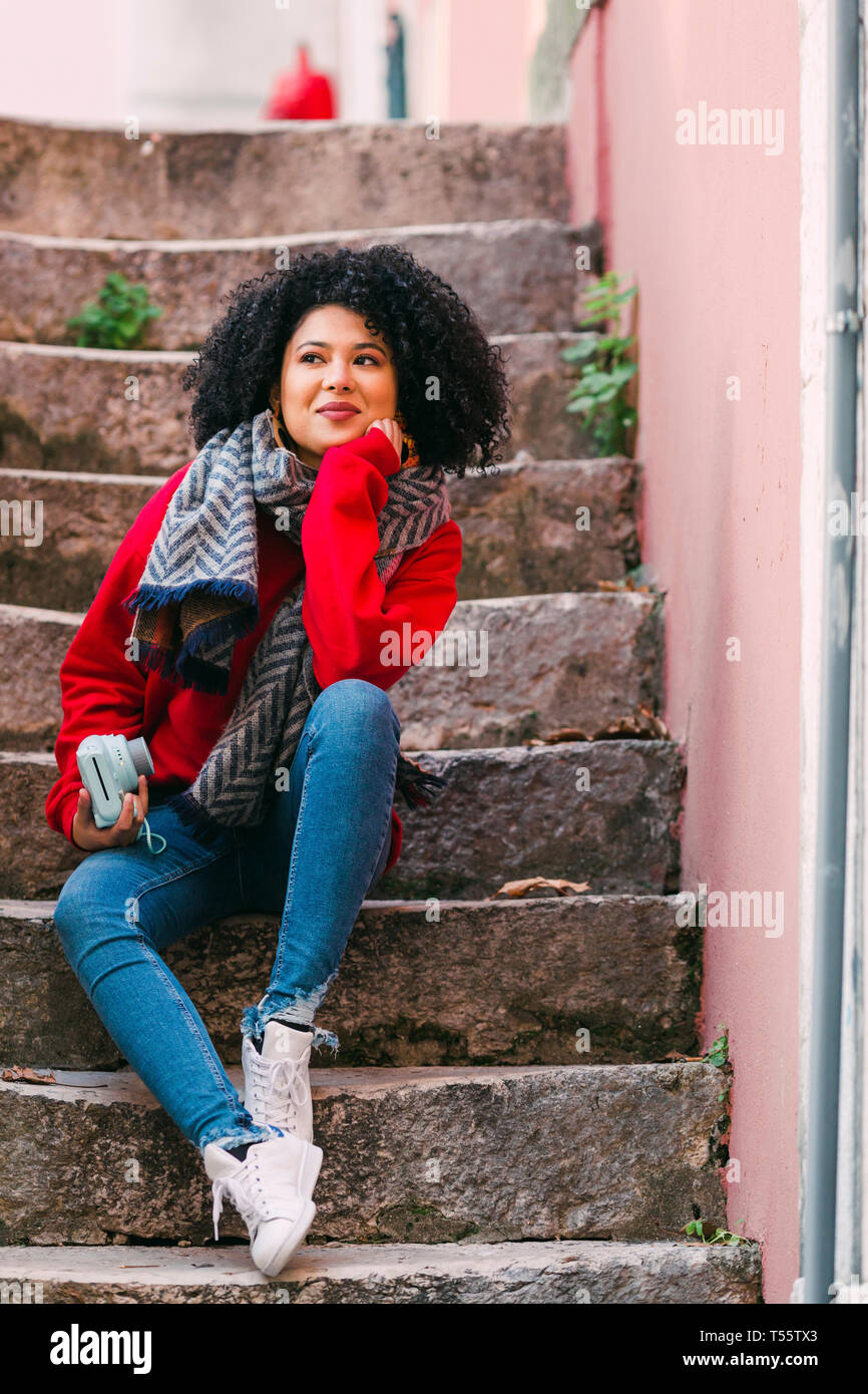 Young woman holding camera on staircase Stock Photo - Alamy