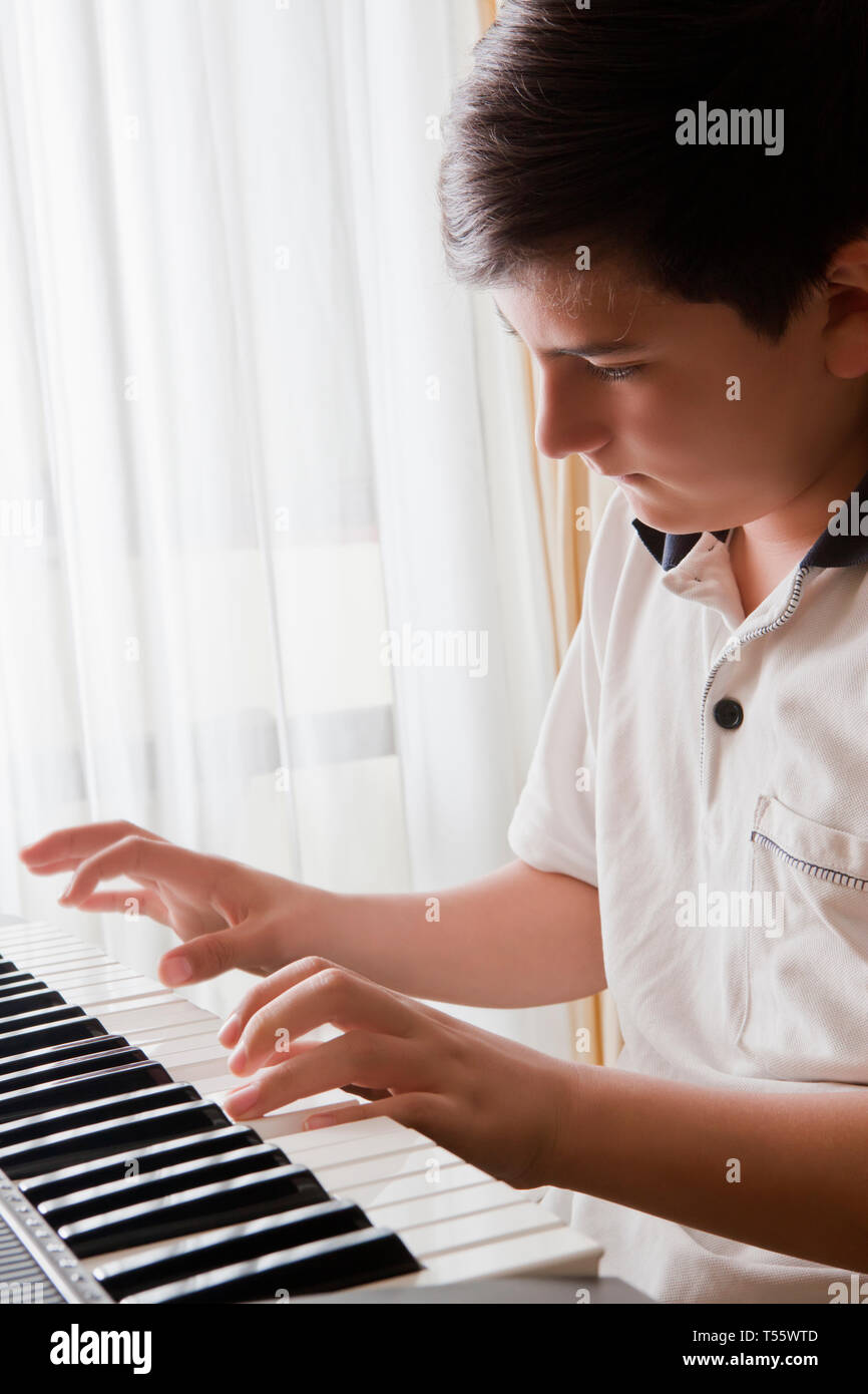 Boy playing piano hi-res stock photography and images - Alamy
