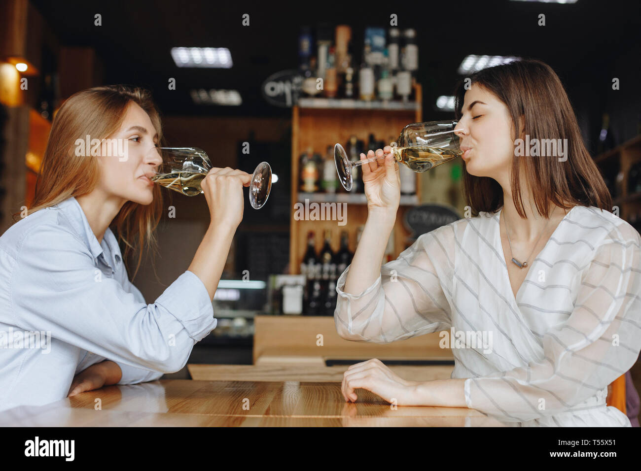 Young women drinking white wine Stock Photo - Alamy